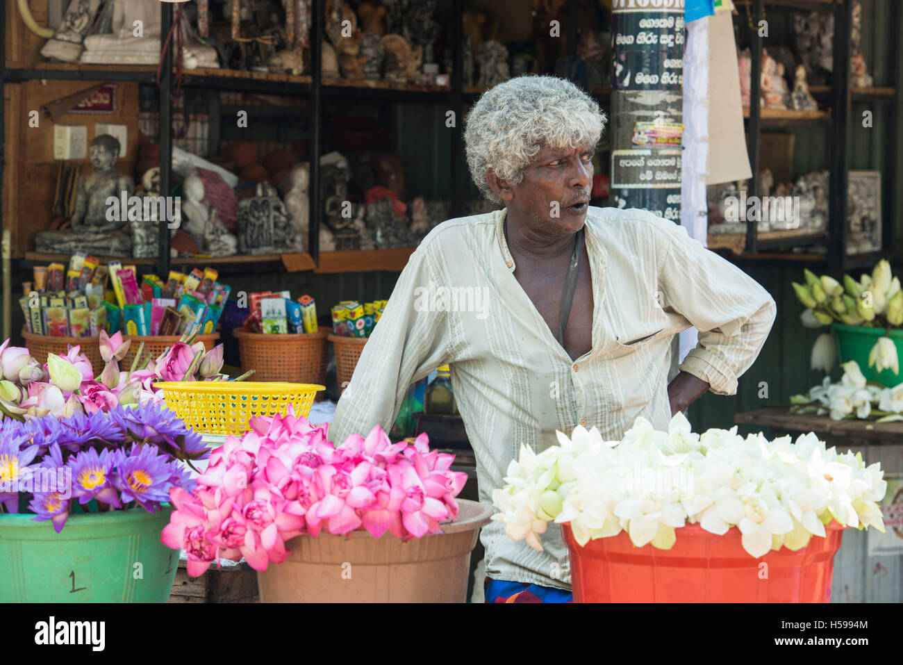 Man selling flowers for offerings in the sacred world heritage city of ...
