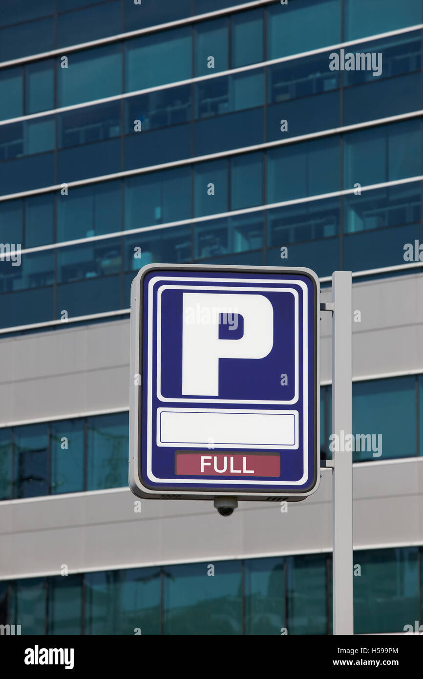 Parking signpost with full text and modern building background ...
