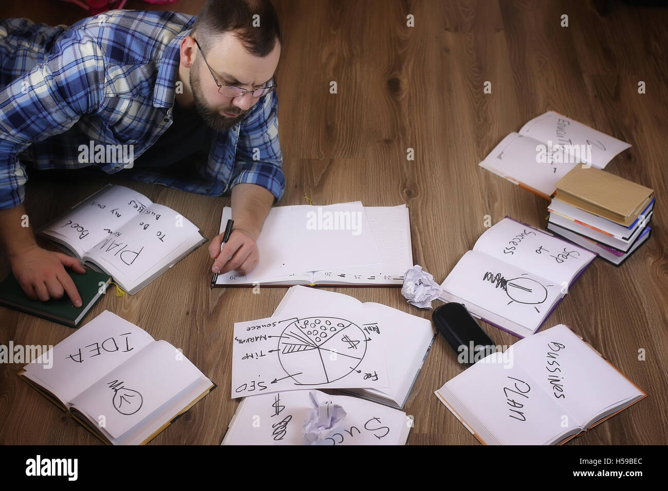 man working with book on the floor Stock Photo - Alamy