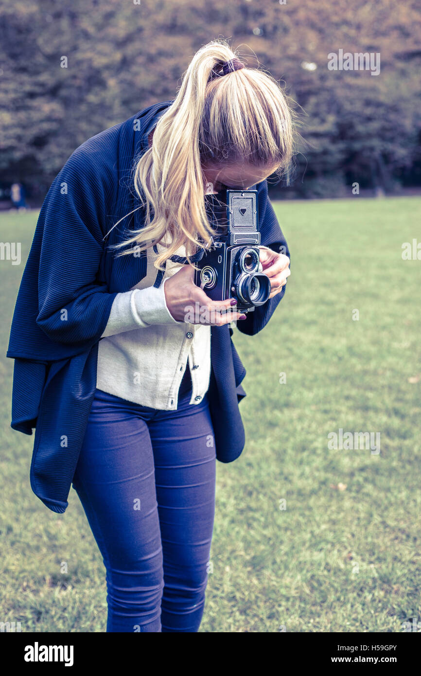 Young woman taking picture with old classic photo camera Stock Photo ...