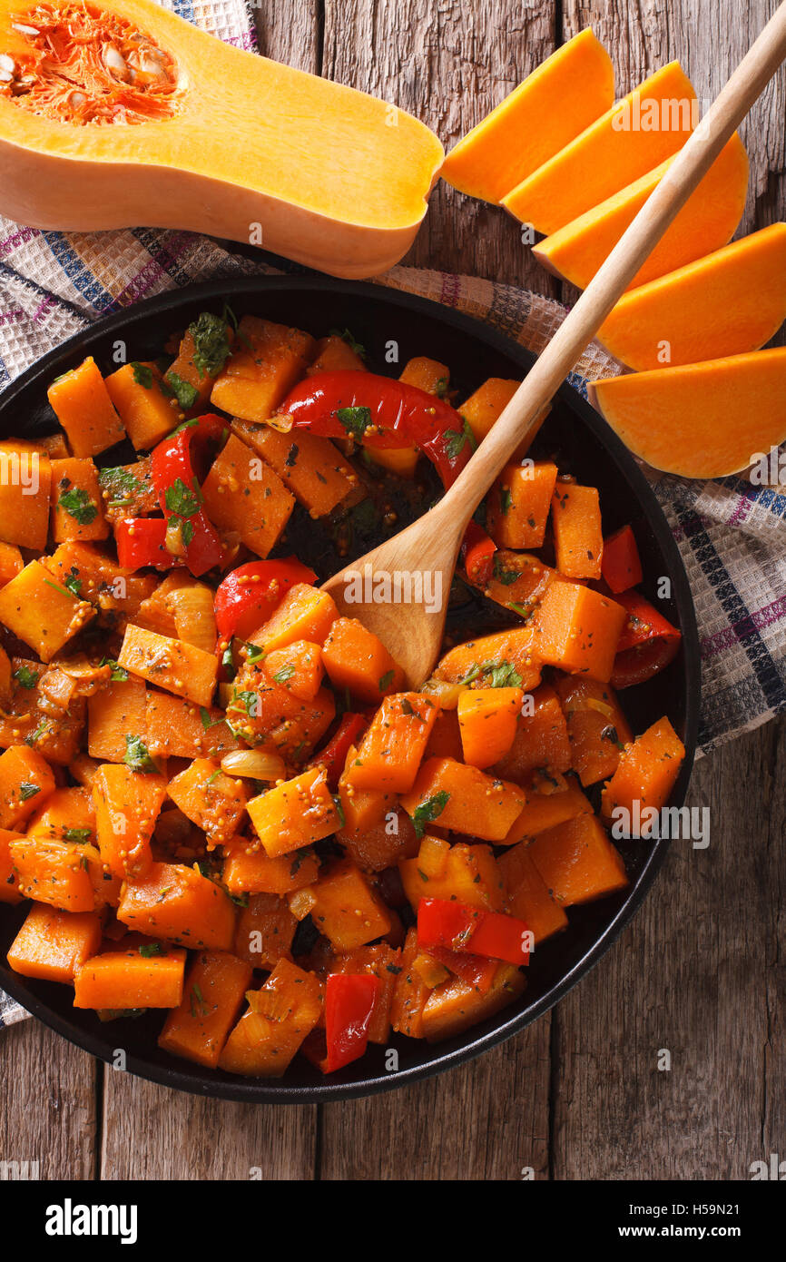 Vegetarian food: pumpkin curry on a plate close-up. Vertical top view ...
