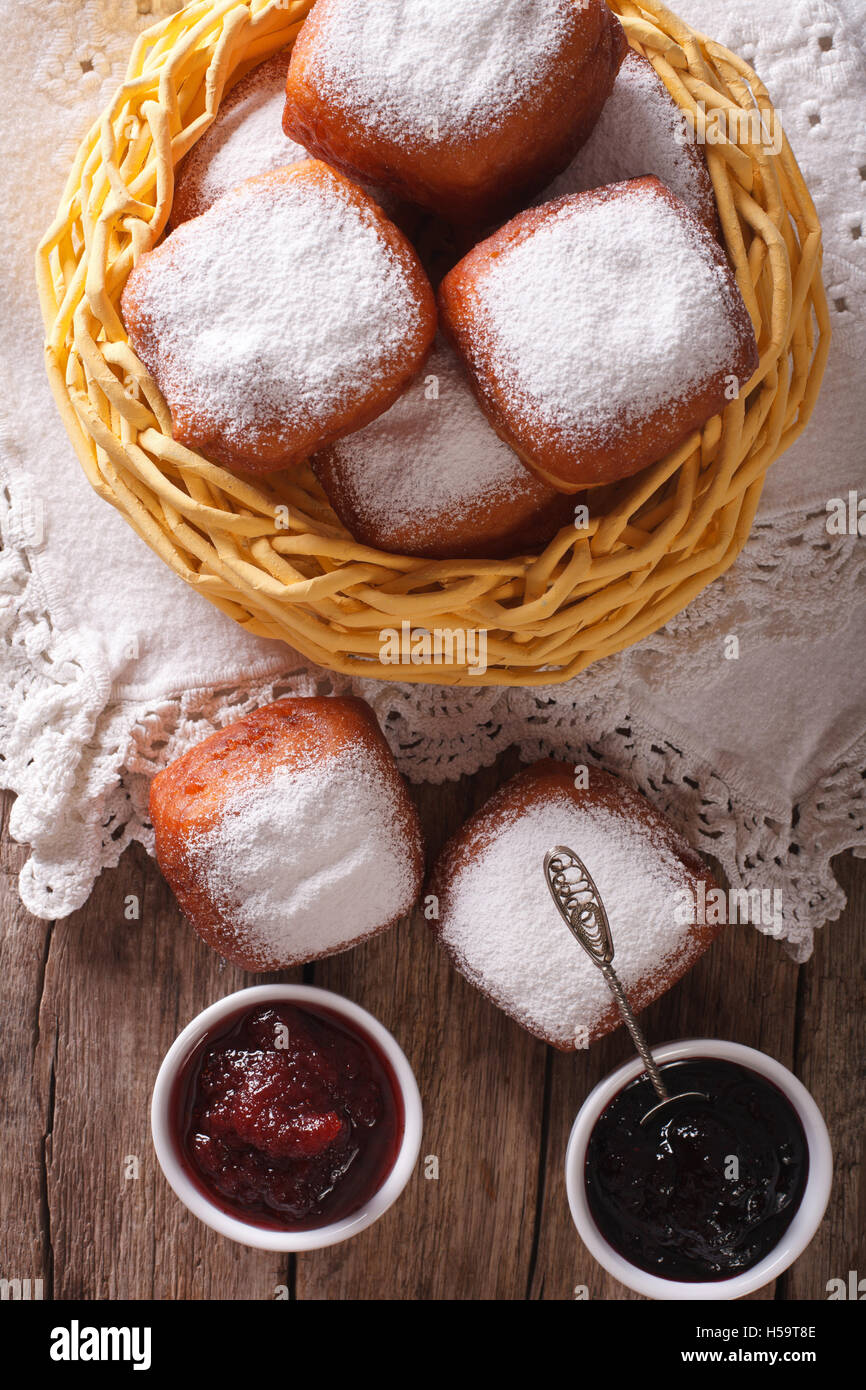 Sweet donuts beignets with powdered sugar and jam closeup on the table ...