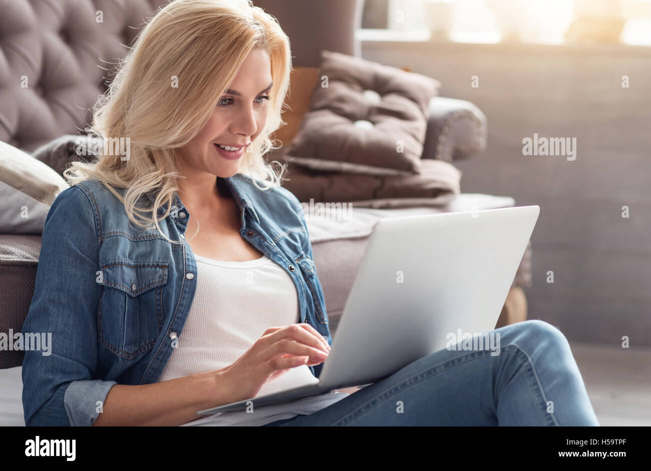 Blond woman working with laptop at home Stock Photo - Alamy