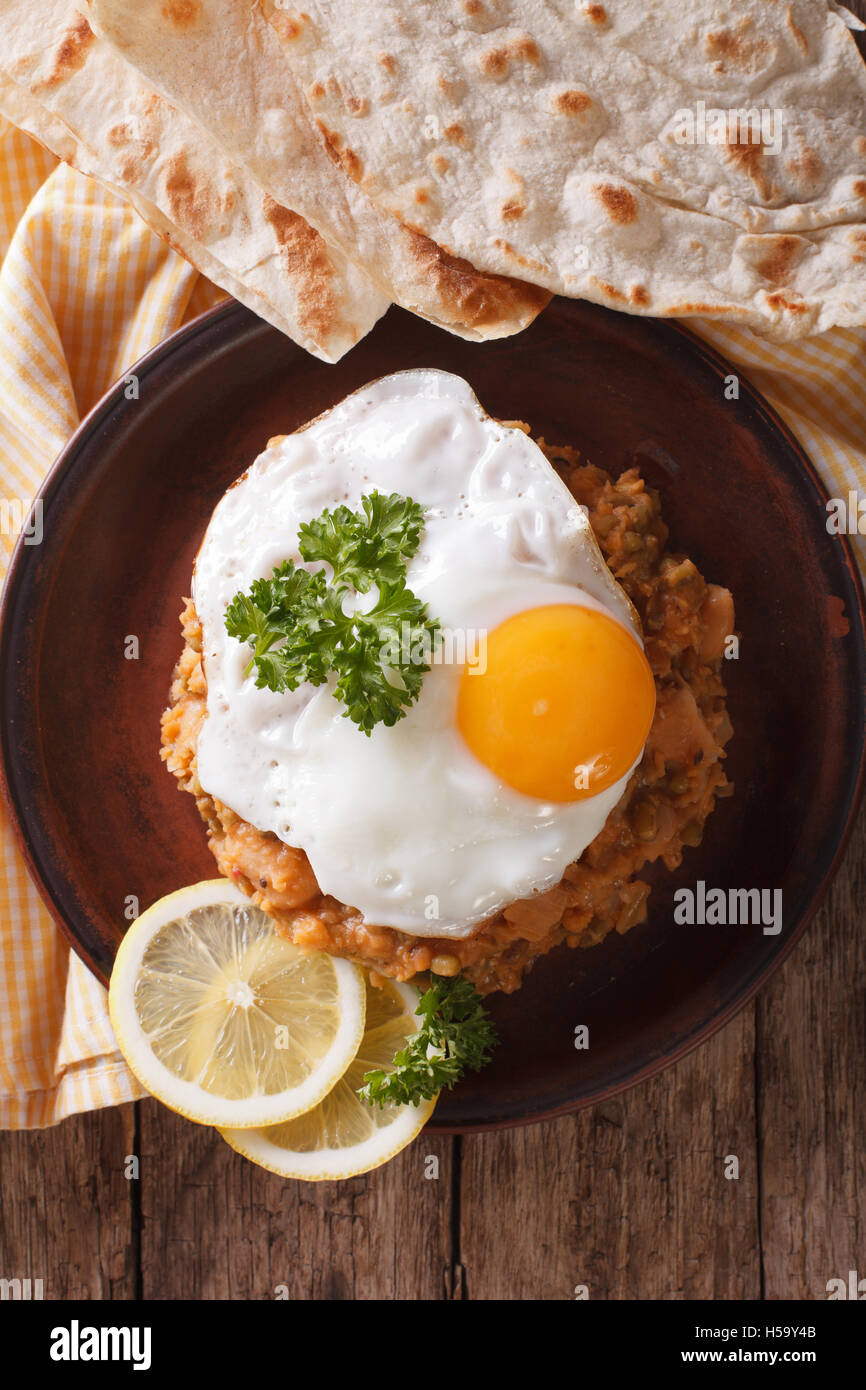 Egyptian breakfast: ful medames with a fried egg and bread close-up on ...