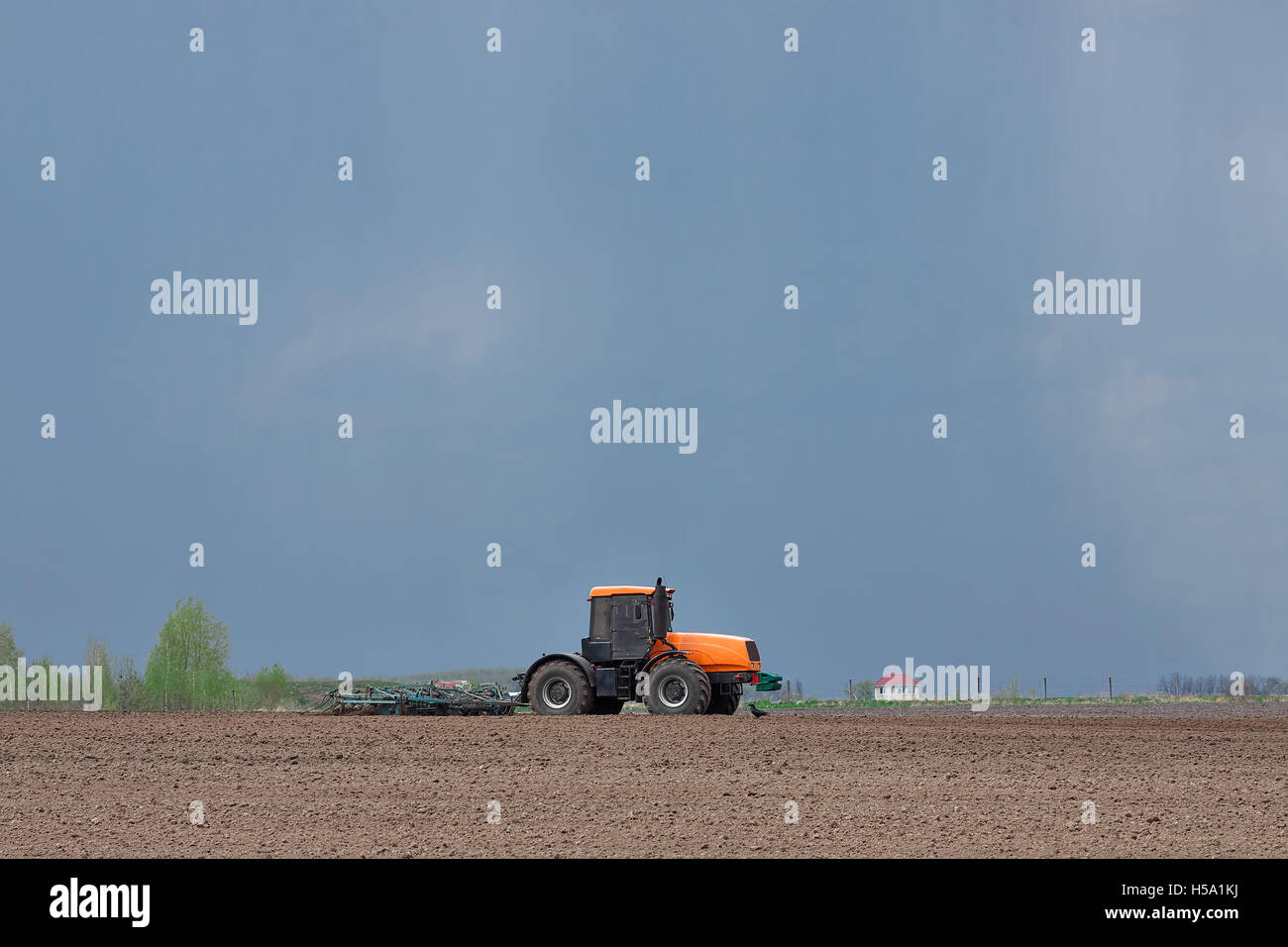 Tillage - tractor preparing the soil for seeding with a cultivator ...