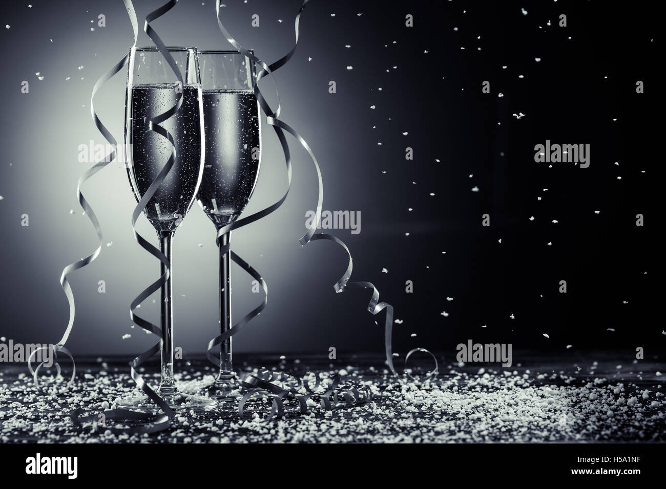 Stylish image of champagne glasses on dark background with snowfall ...