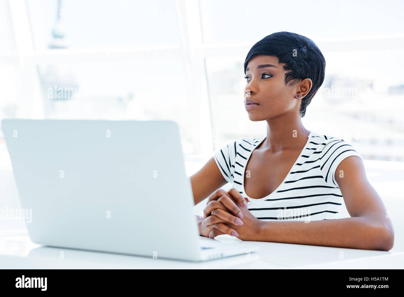 Portrait of a casual young african businesswoman using laptop computer ...