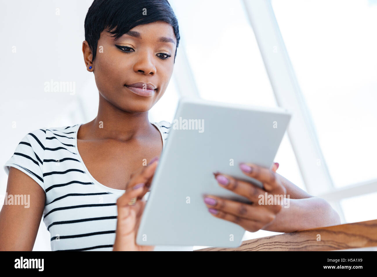 Attractive afro american businesswoman using tablet computer in office ...