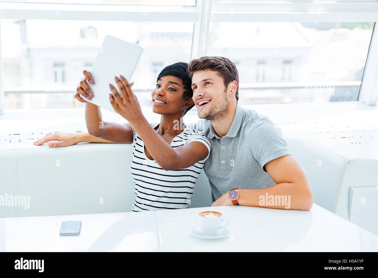 Happy young couple in love taking selfie with pc tablet in restaurant ...