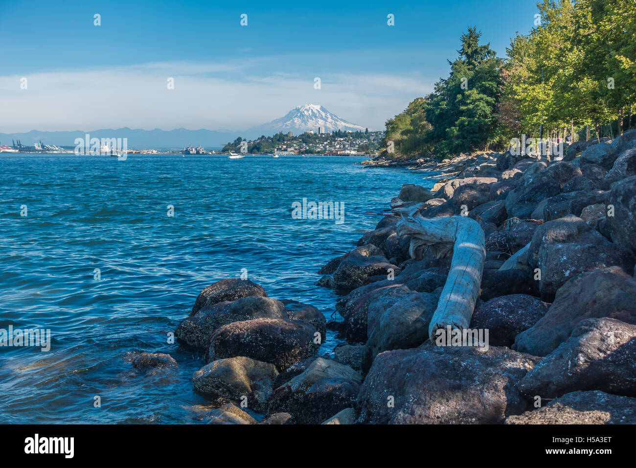 Rocks line the shore in Ruston, Washington. Mount Rainier can be seen ...