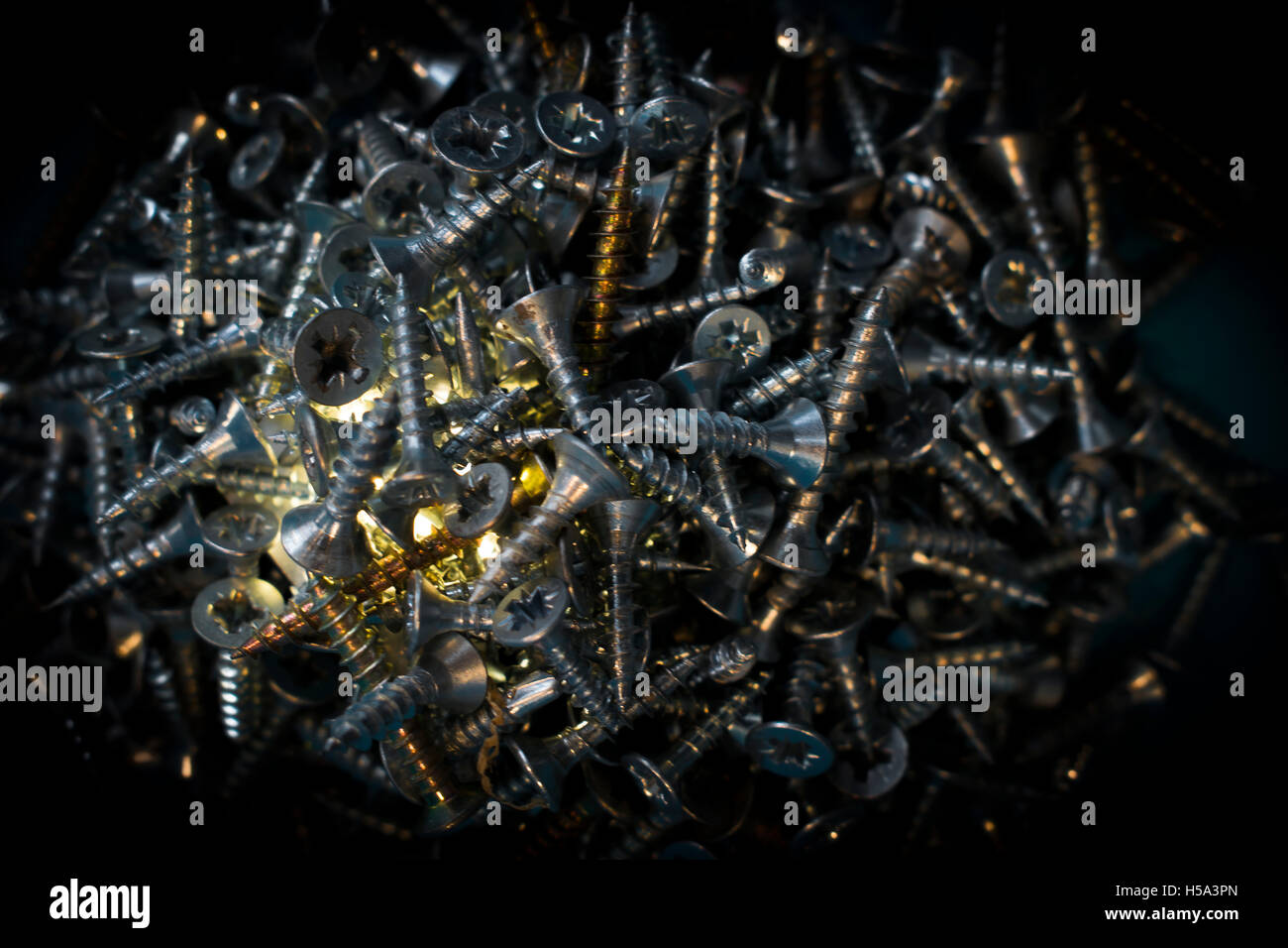 Close up view of pile of screws on dark background Stock Photo - Alamy