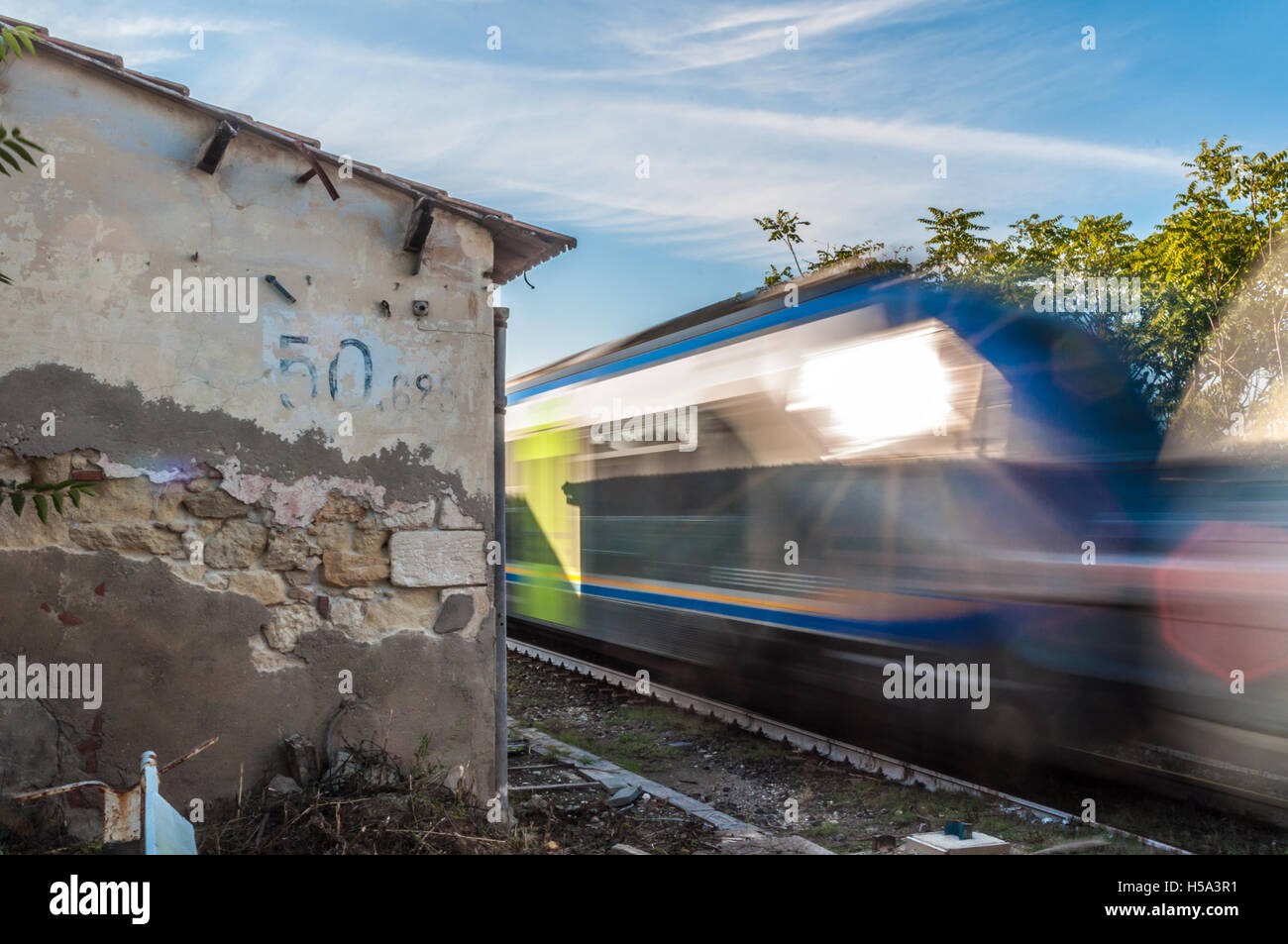 Train running near an abandoned rural rail station Stock Photo - Alamy