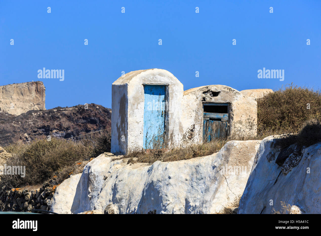 Dilapidated buildings with rotting doors and peeling blue paintwork in ...