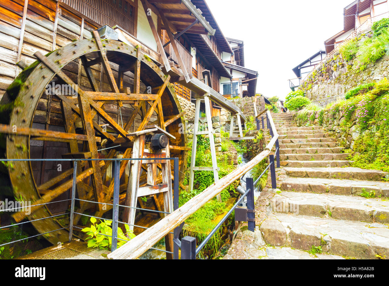 A traditional turning wooden waterwheel motion blurred by a stream next ...