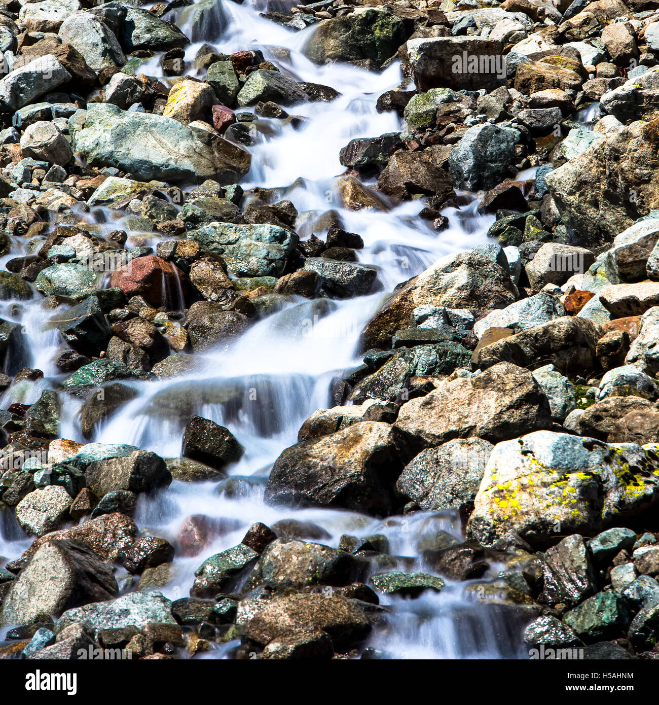 Waterfall between the rocks of the mountains in the Alps Stock Photo ...