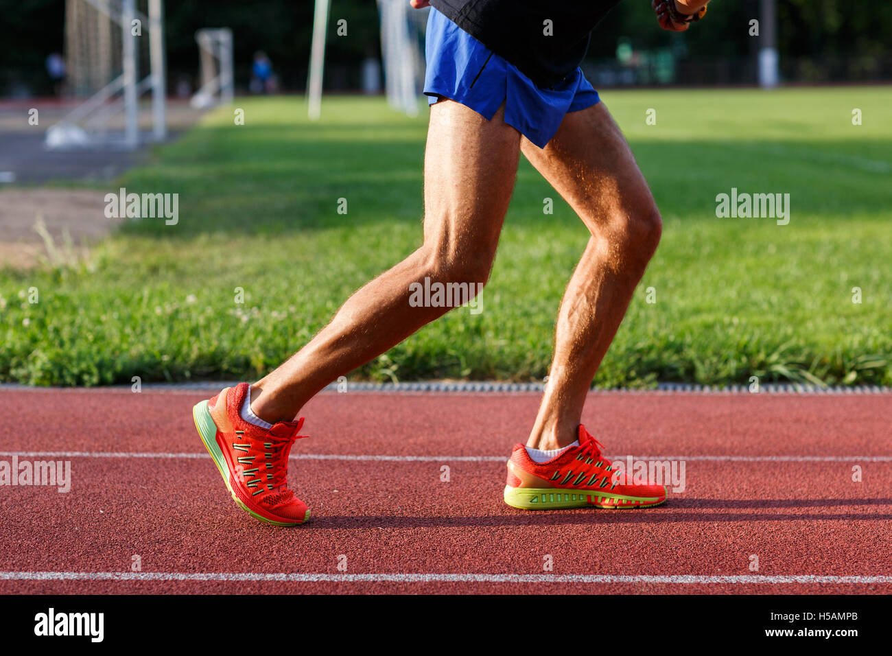 Muscular legs of men in shorts and sports shoes Stock Photo - Alamy