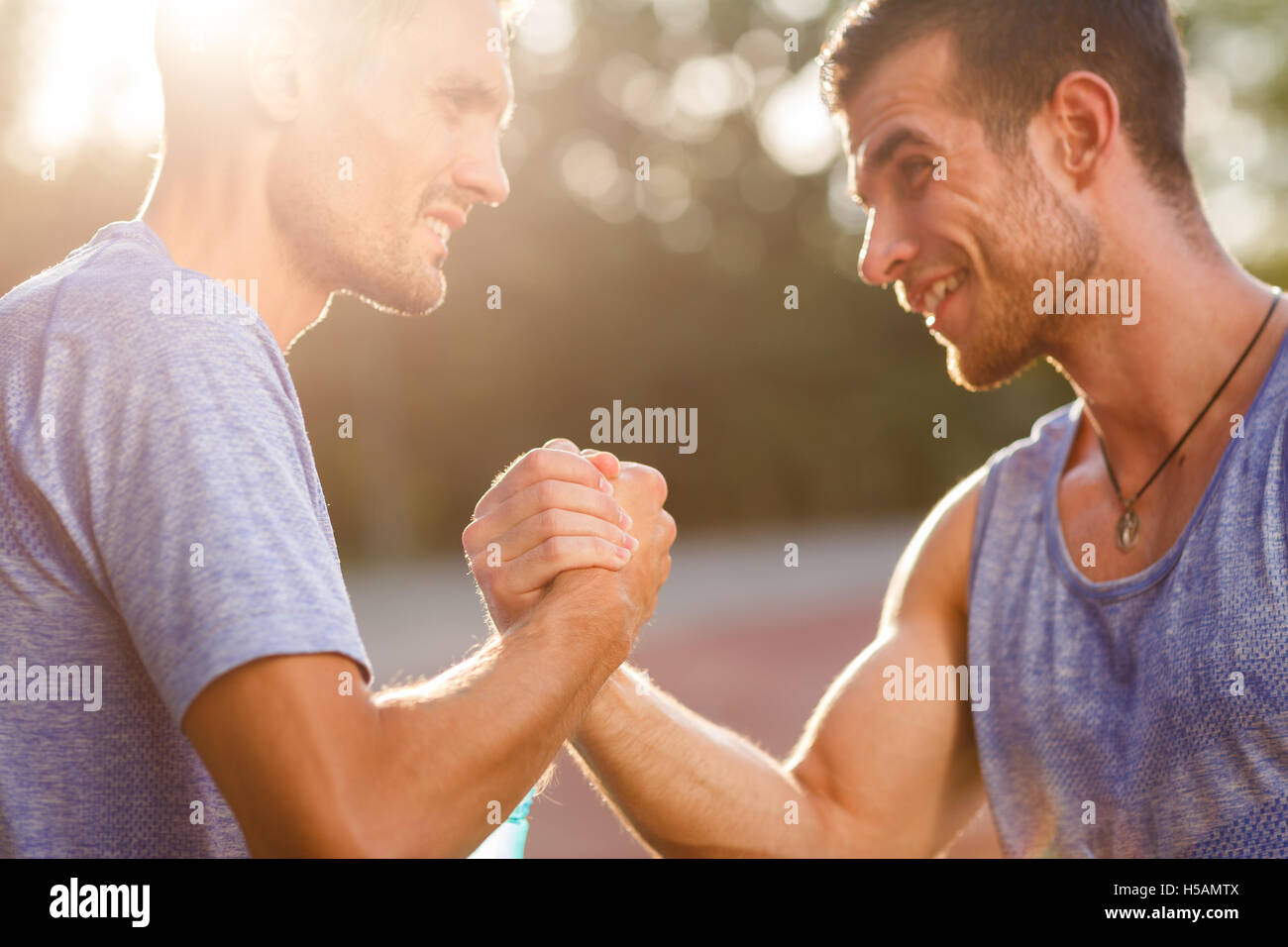 Two hot men shake each others hands on summer day Stock Photo - Alamy