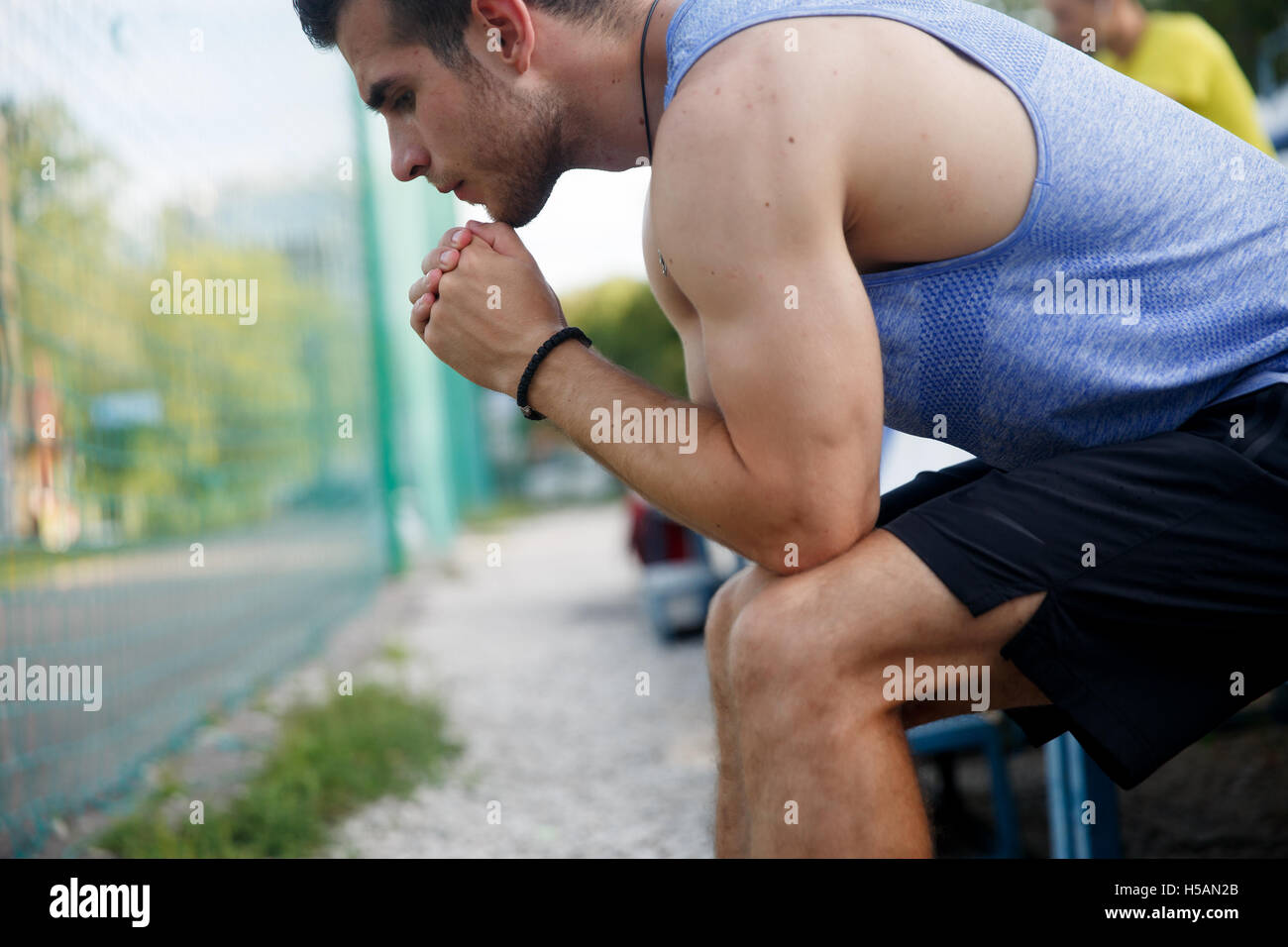 Fitness guy resting after workout on bench in street stadium Stock ...