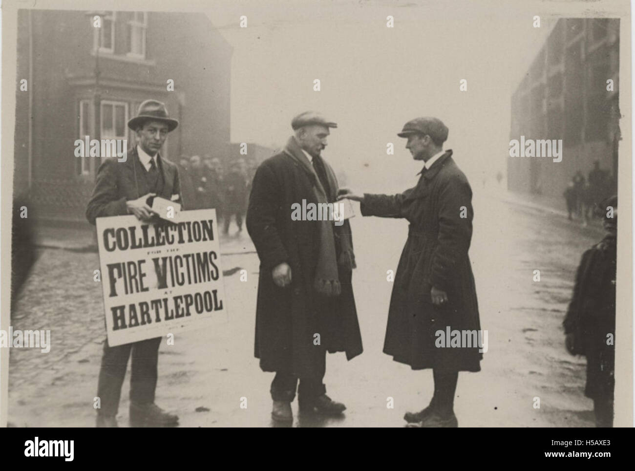 The image depicts people collecting donations for victims of a disaster ...