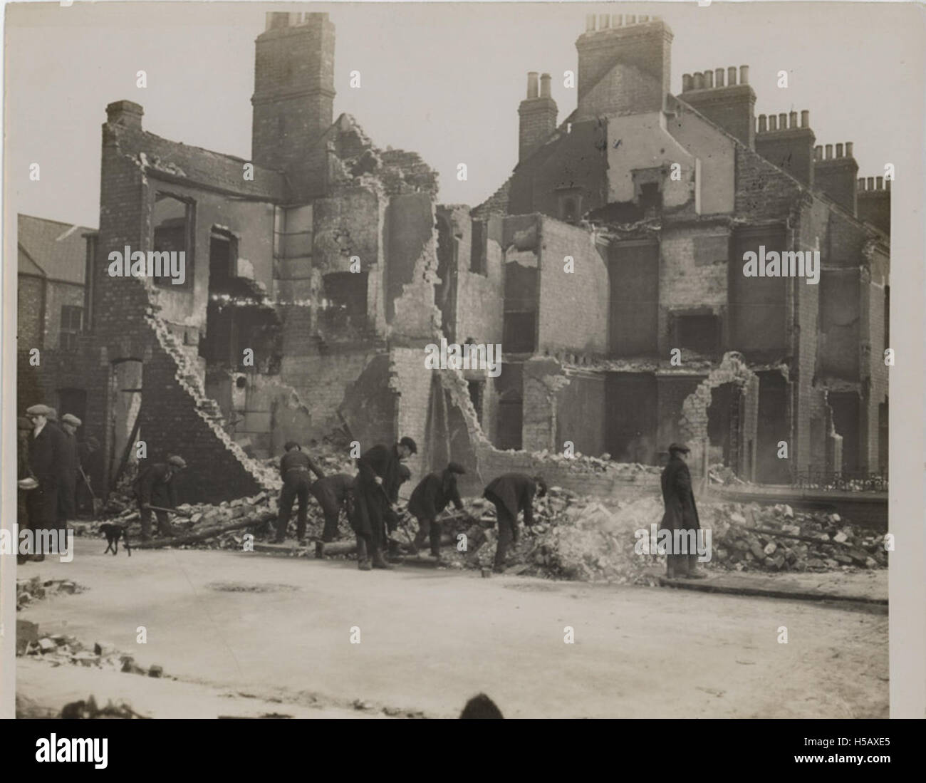 This photograph captures individuals searching through rubble, likely ...