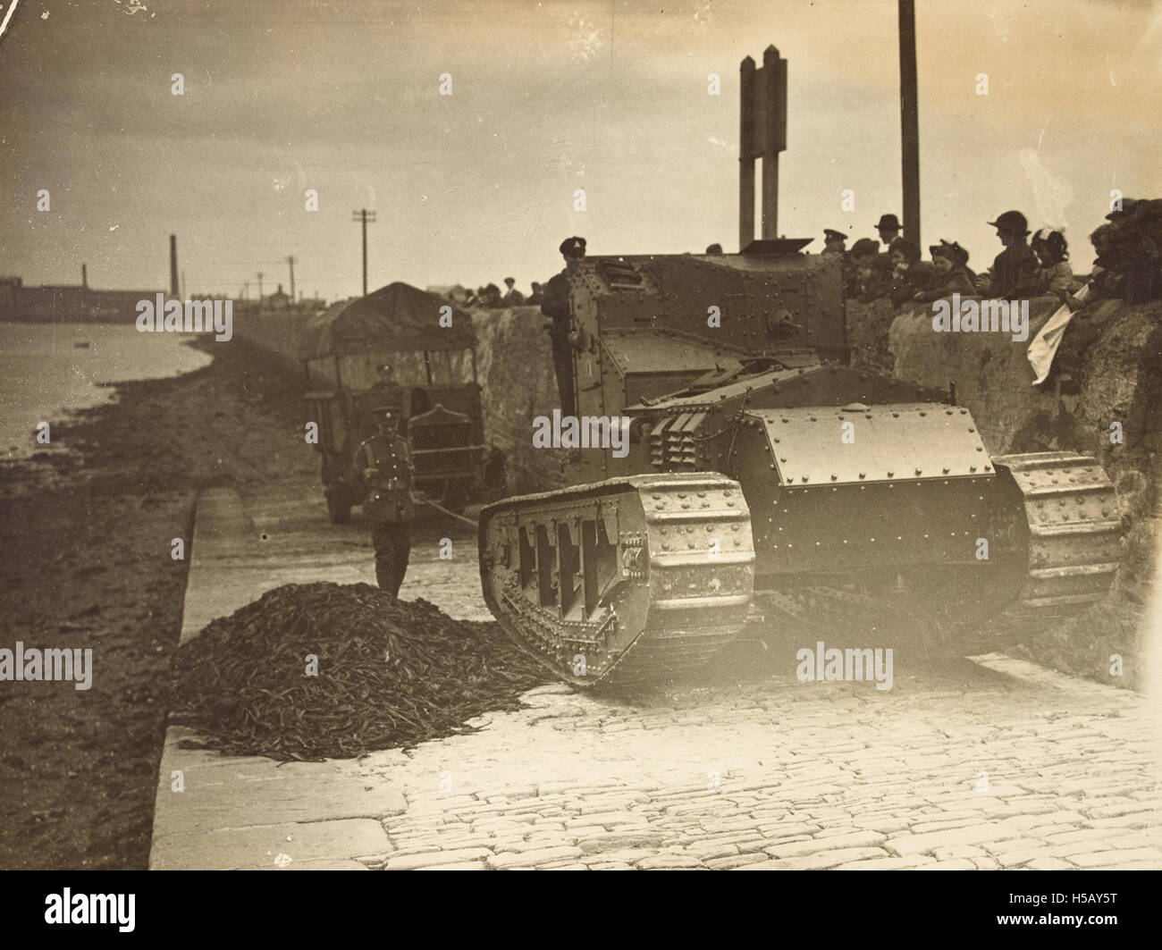 A tank is seen pulling a three-ton military truck from the banks of the ...