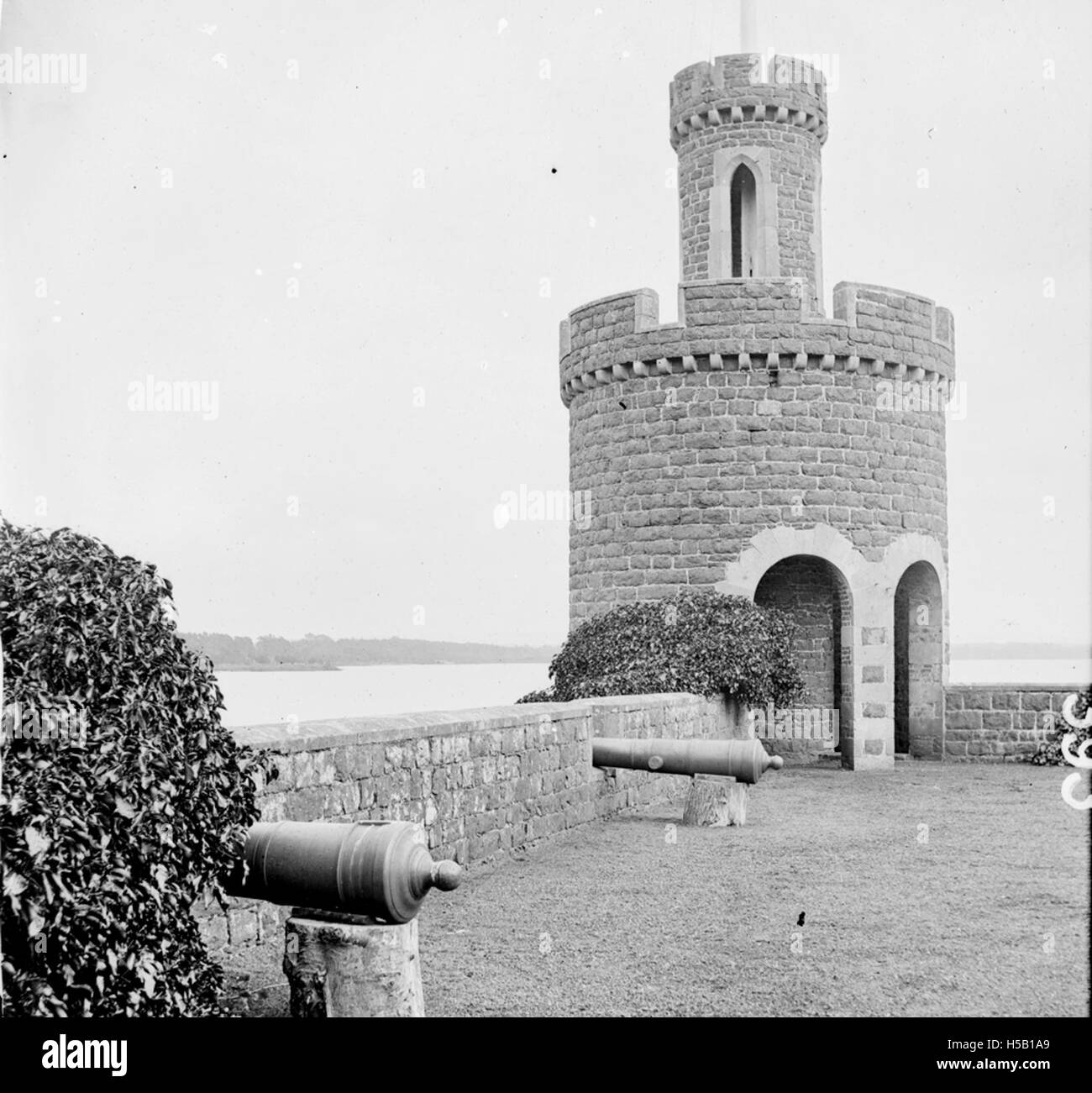 The image depicts a brick tower with a turret, featuring a distinctive ...