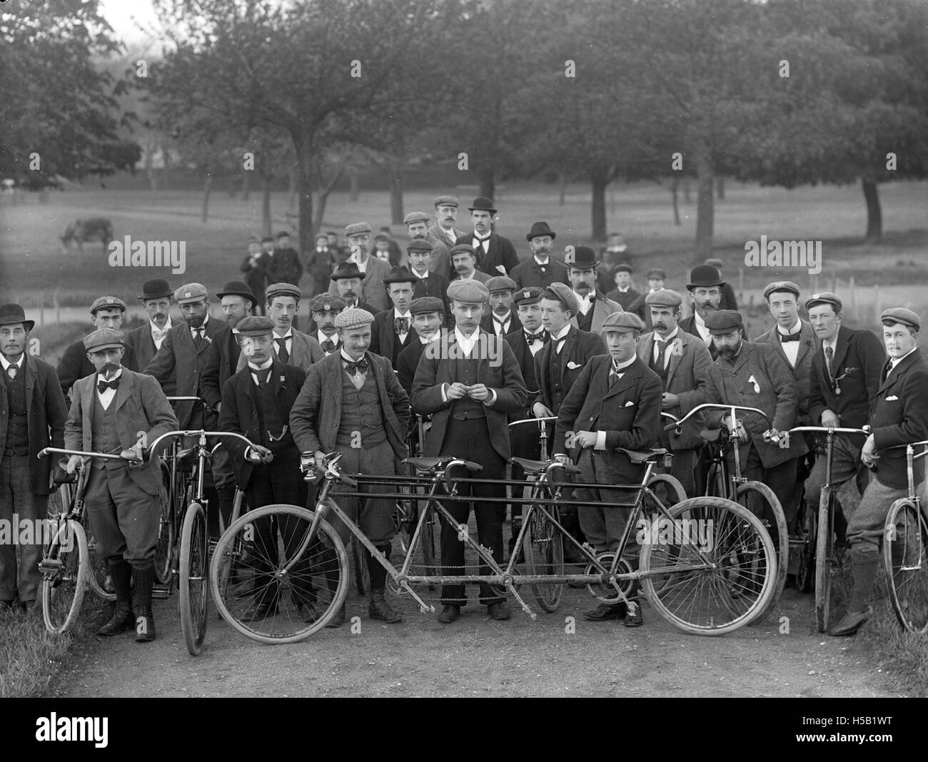 This photograph shows three people riding a bicycle designed for three ...