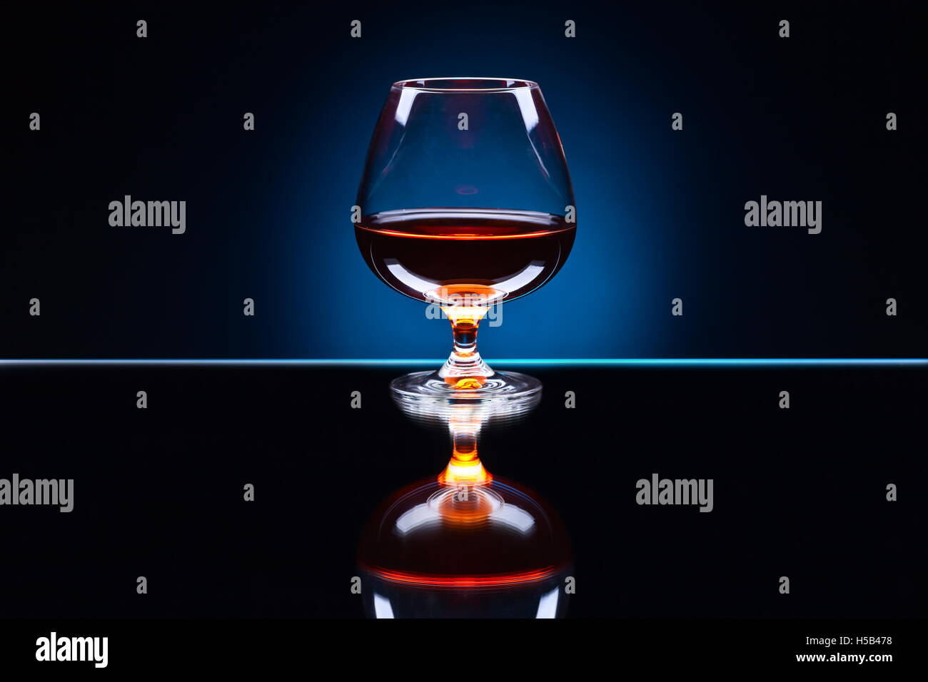 Snifter with brandy on a reflective background Stock Photo - Alamy