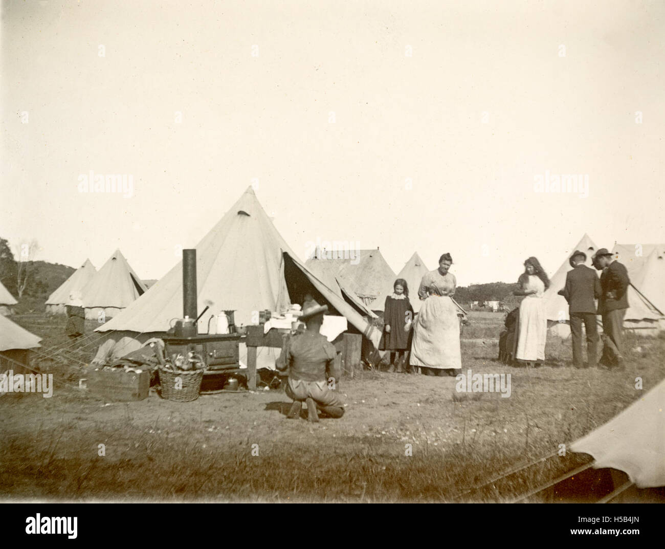 This historical image depicts a camp scene from around 1901, capturing ...