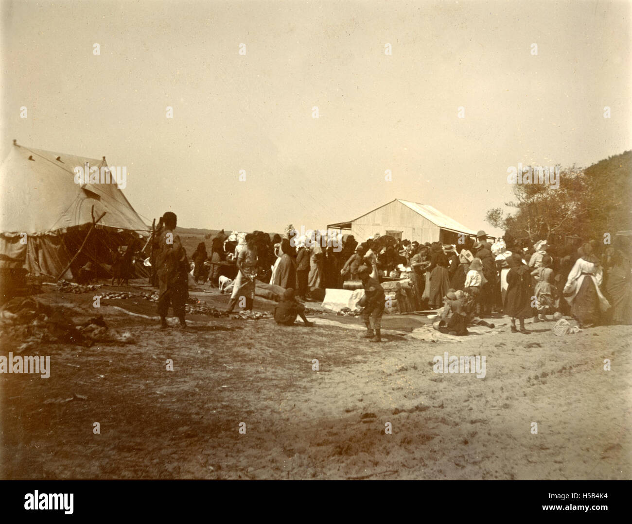 This photograph shows the distribution of food rations at a camp around ...
