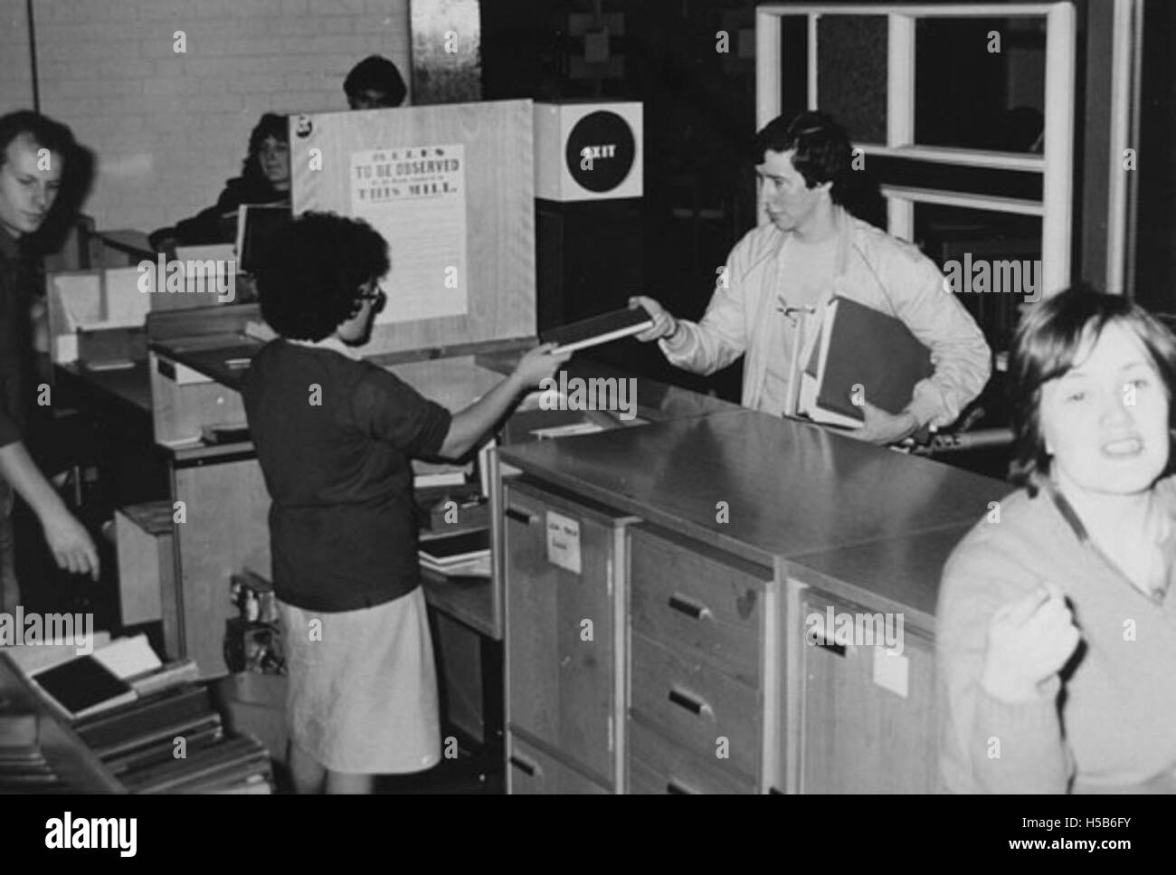 The photograph taken around 1981 showcases a library setting, likely ...