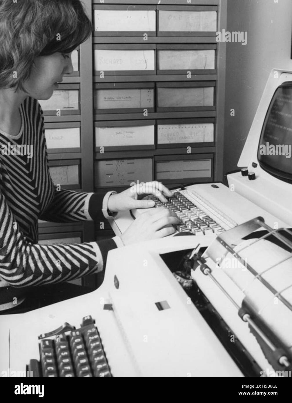 A student is pictured using a computer in the 1970s, showcasing early ...