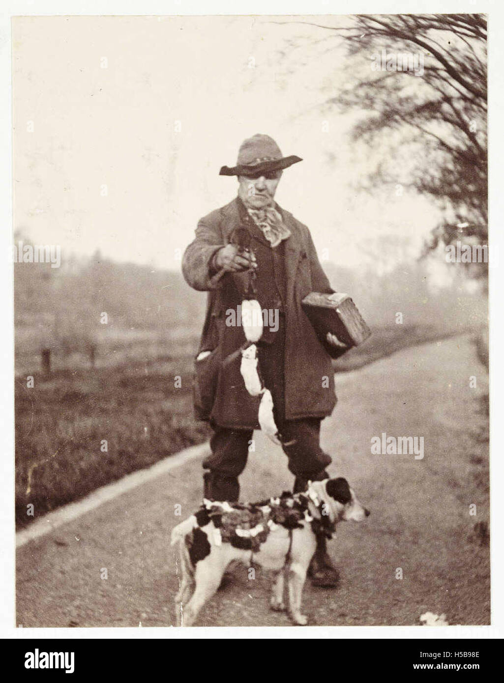 A historical photograph of a rat catcher accompanied by his dog ...