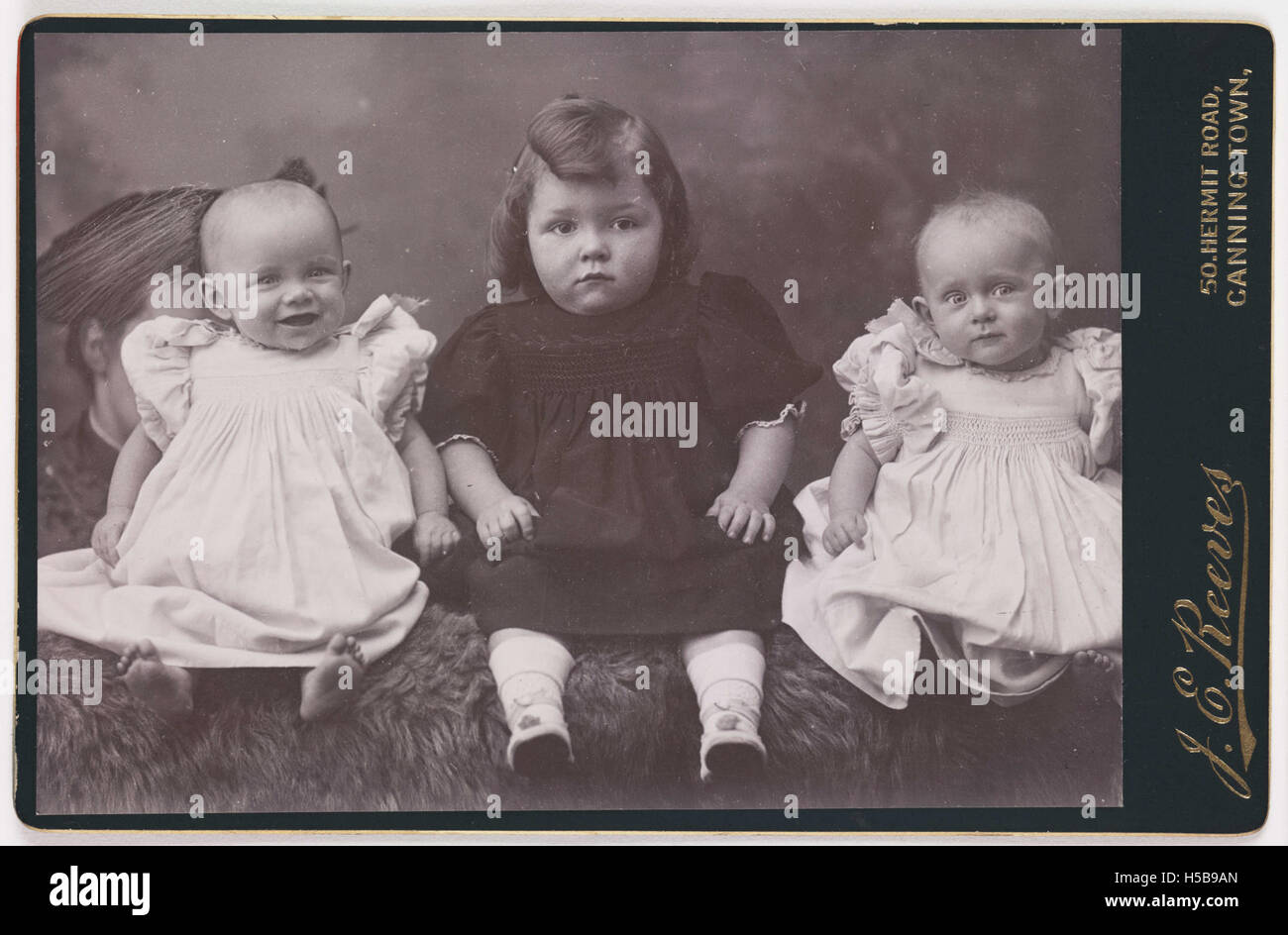 A cabinet card from the late 19th or early 20th century captures three ...