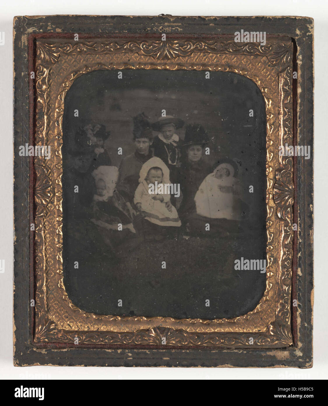This ferrotype photograph depicts a group of people on a beach, with ...