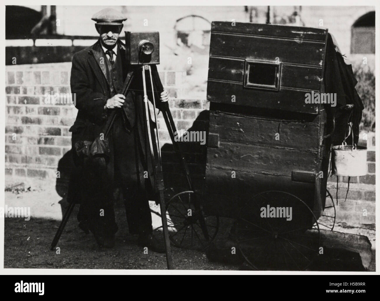 This image shows a street photographer with a cart, capturing scenes of ...