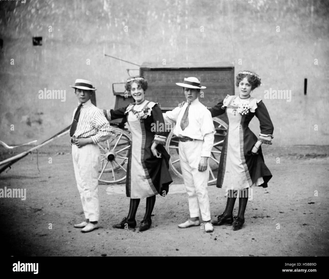 Four circus performers are pictured in front of a wagon, likely during ...