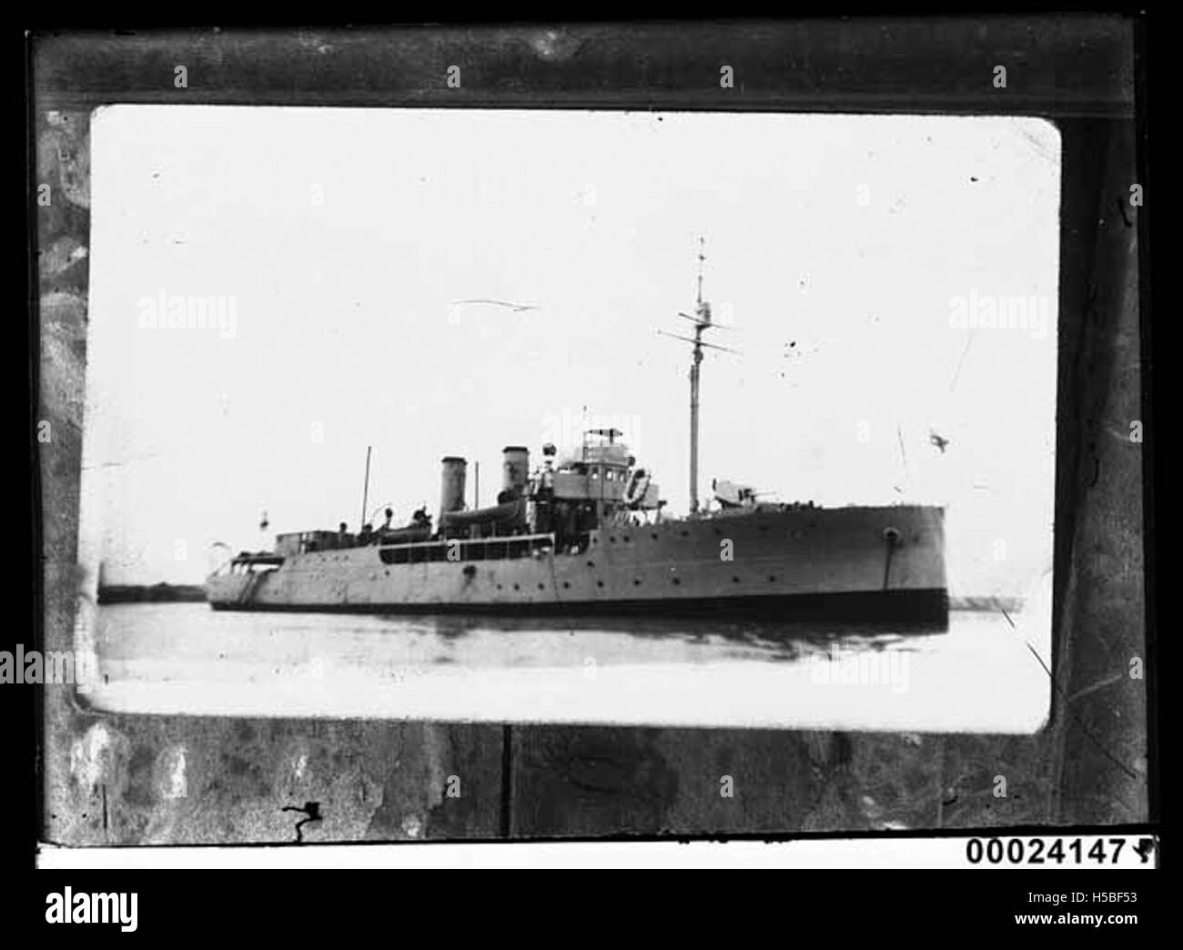 Unidentified two funnel naval warship anchored in unidentified harbour ...