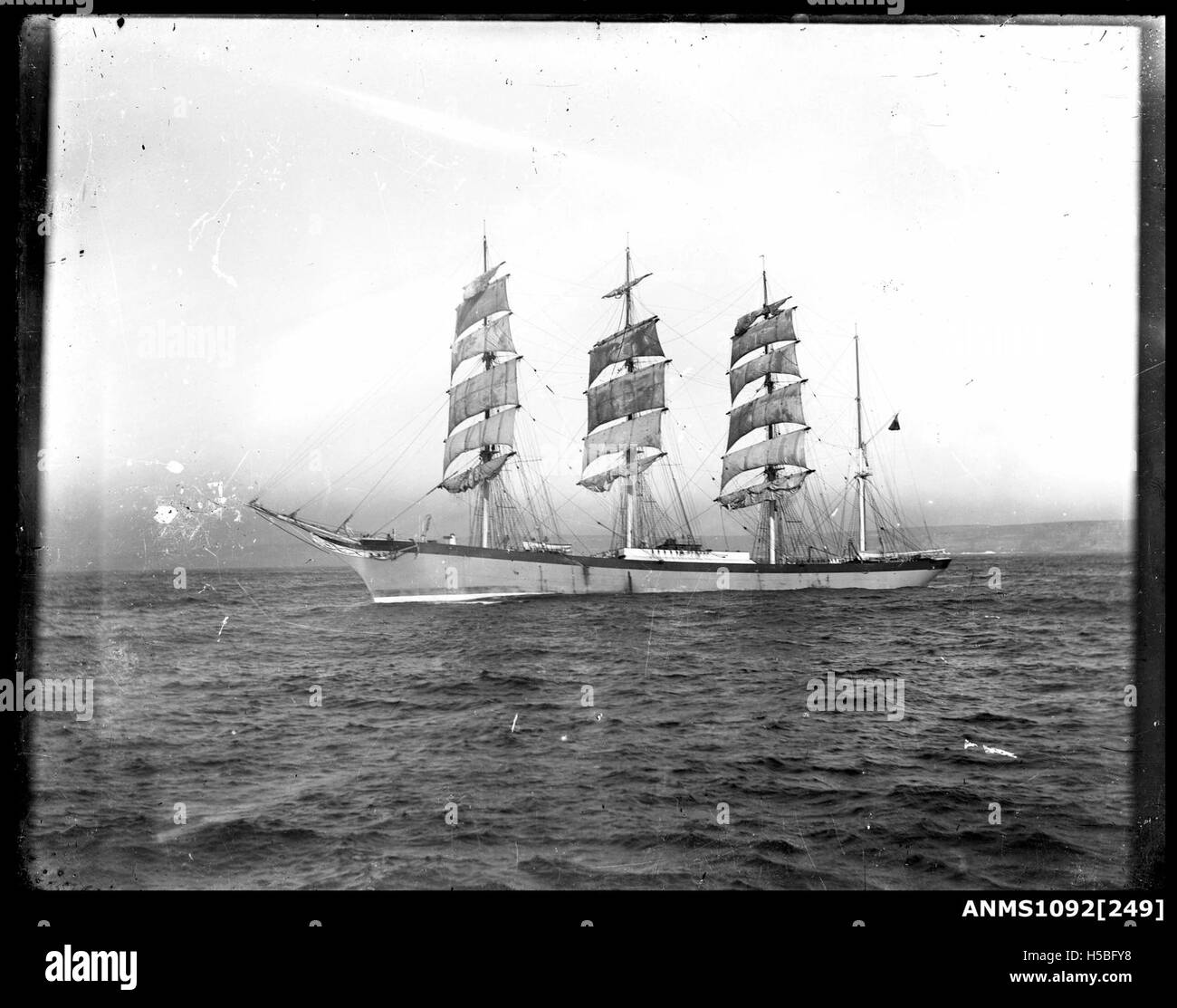 A five-masted barque, an impressive tall ship, sails in open waters ...