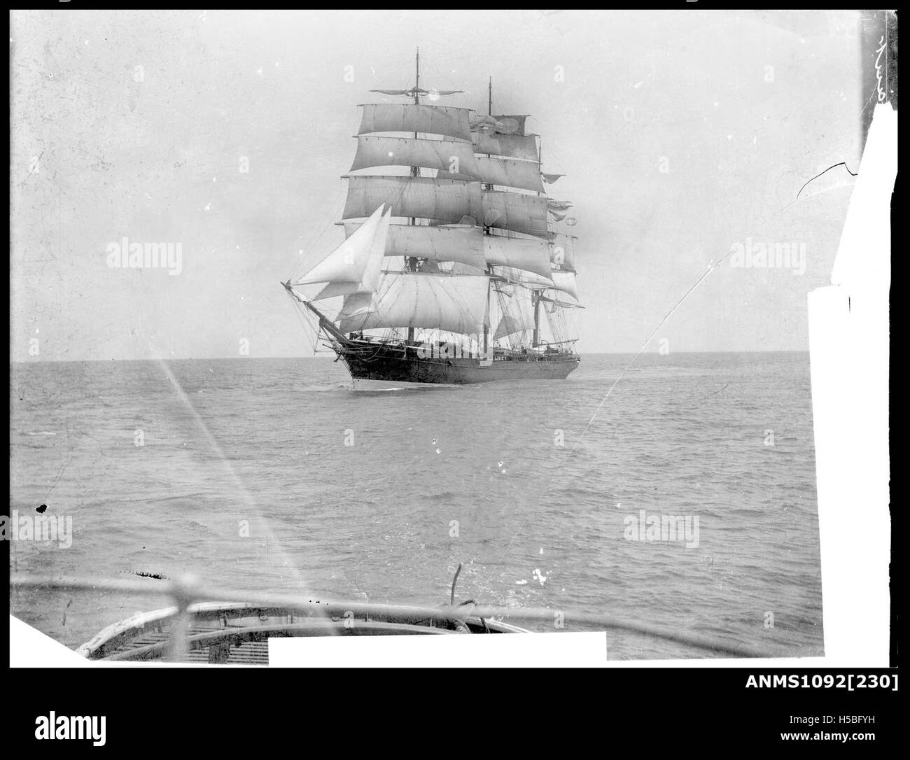 A three-masted ship is shown underway, sailing across the sea. The ...