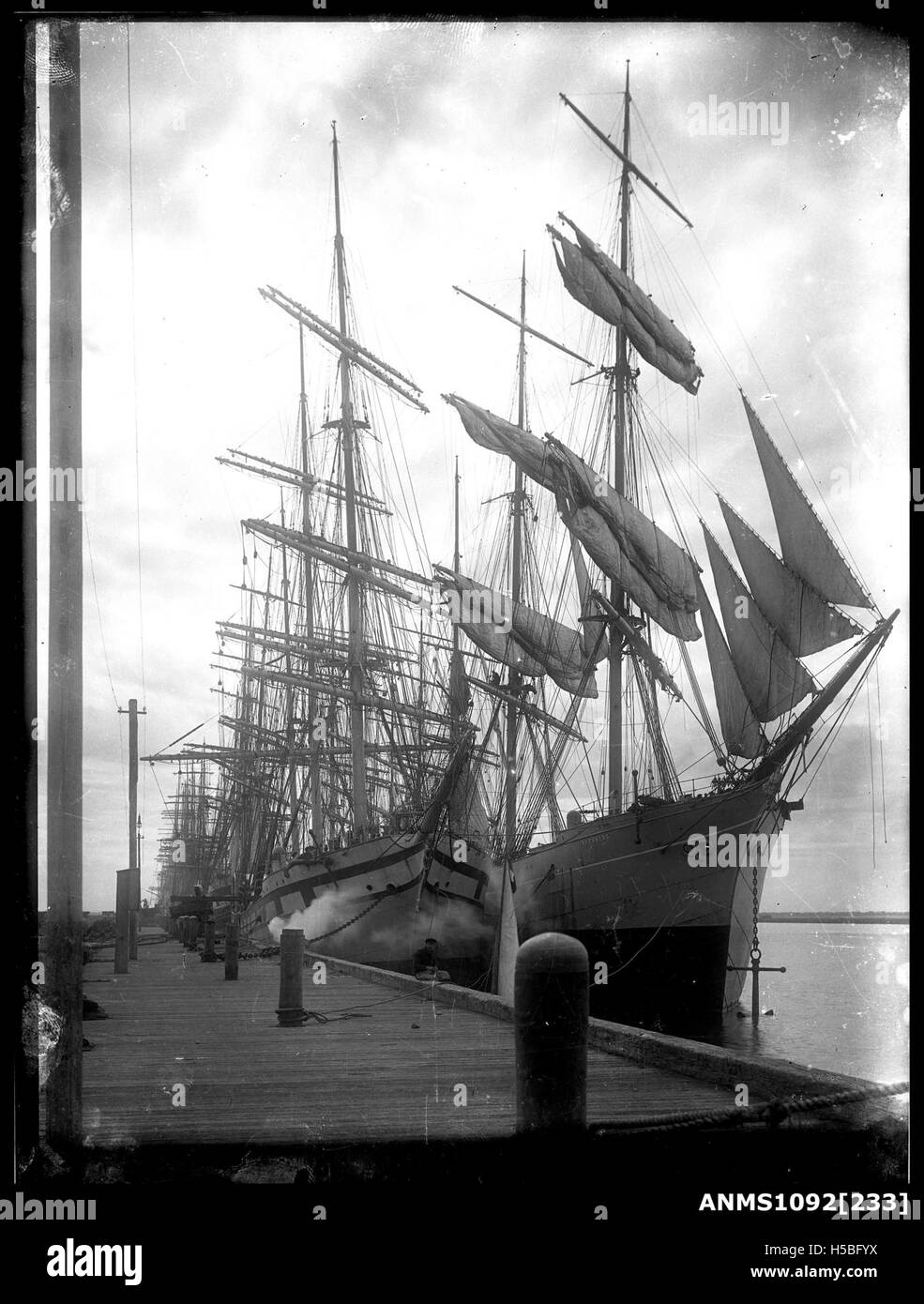Square-rigged sailing ships, including the ship INVERNESS, are docked ...