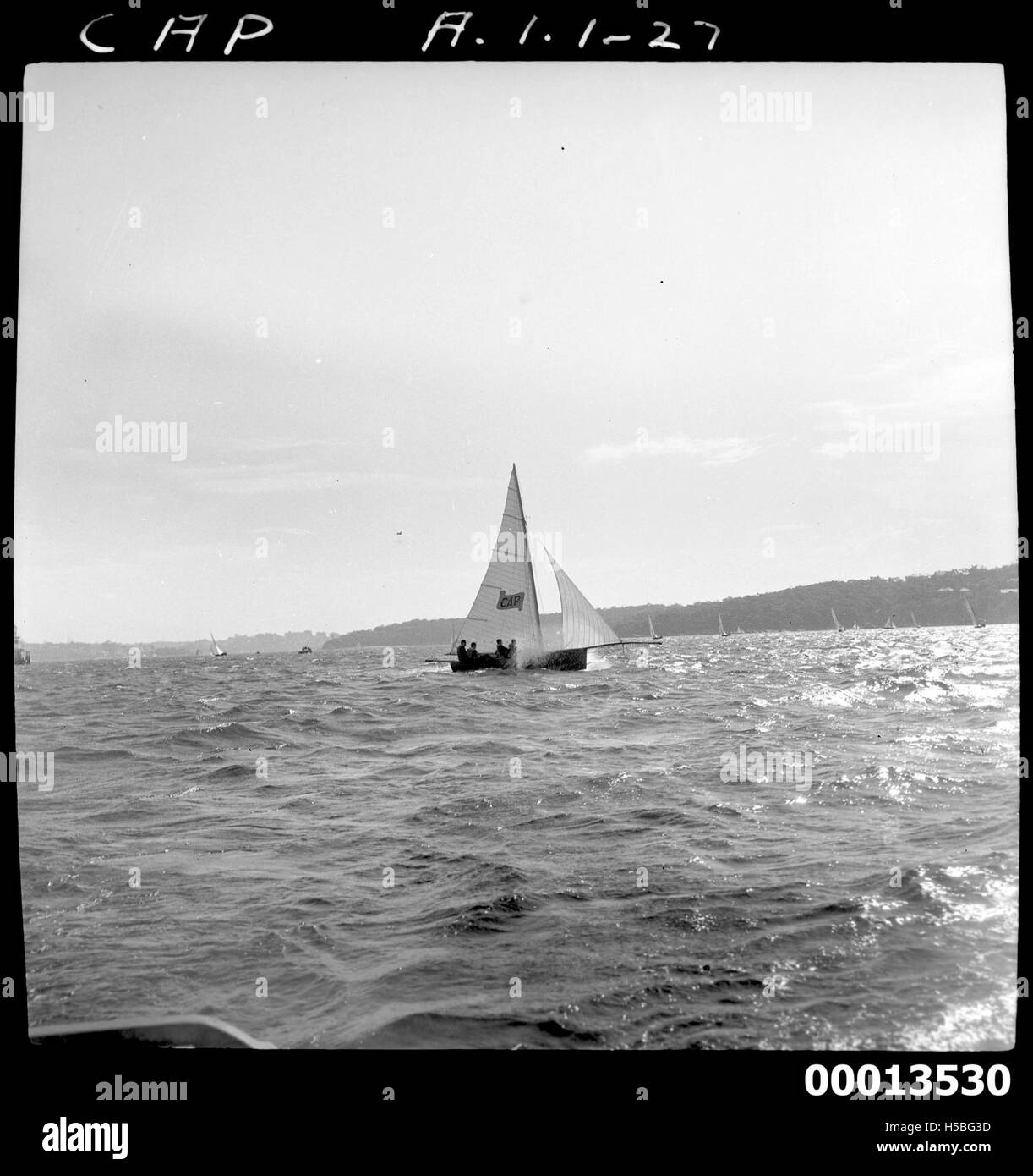 An 18-foot sailing vessel named CAP is shown under full sail on Sydney ...