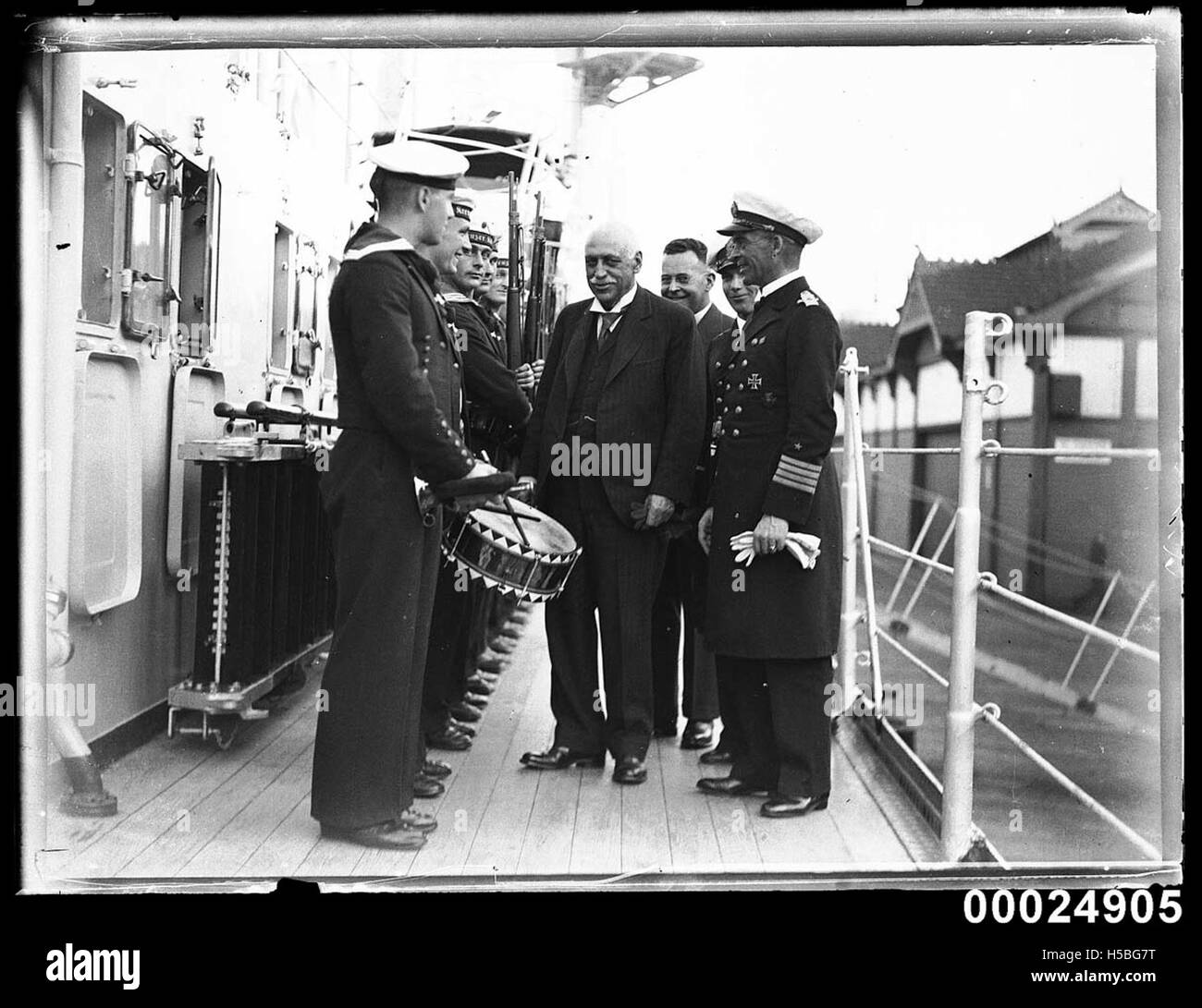A man inspects the crew of the German cruiser KOLN while docked at ...