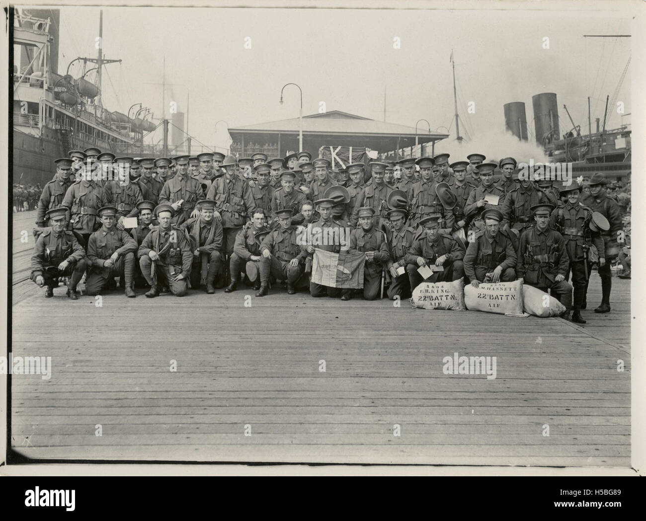 Members of the 22nd Battalion are captured waiting to board the ...