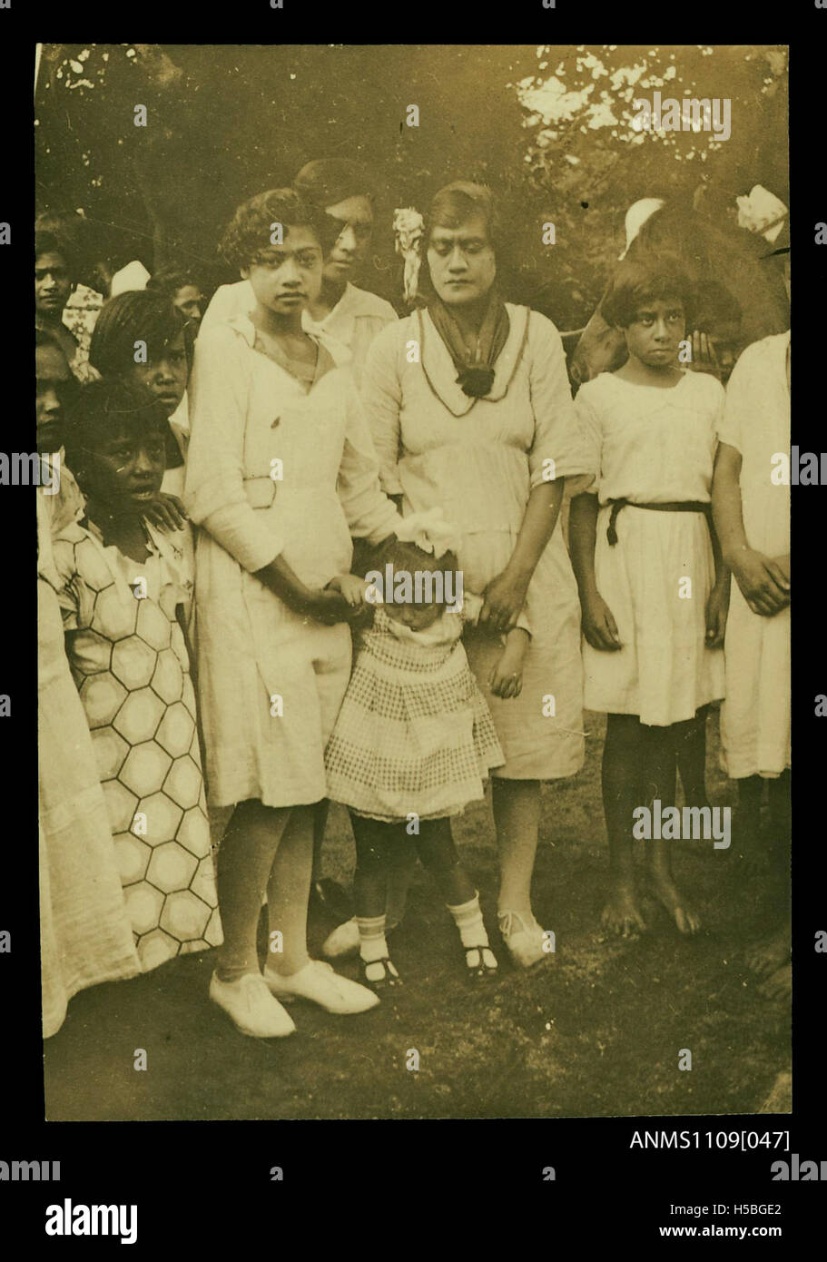 This photograph depicts a group of Pacific Islander women and children ...