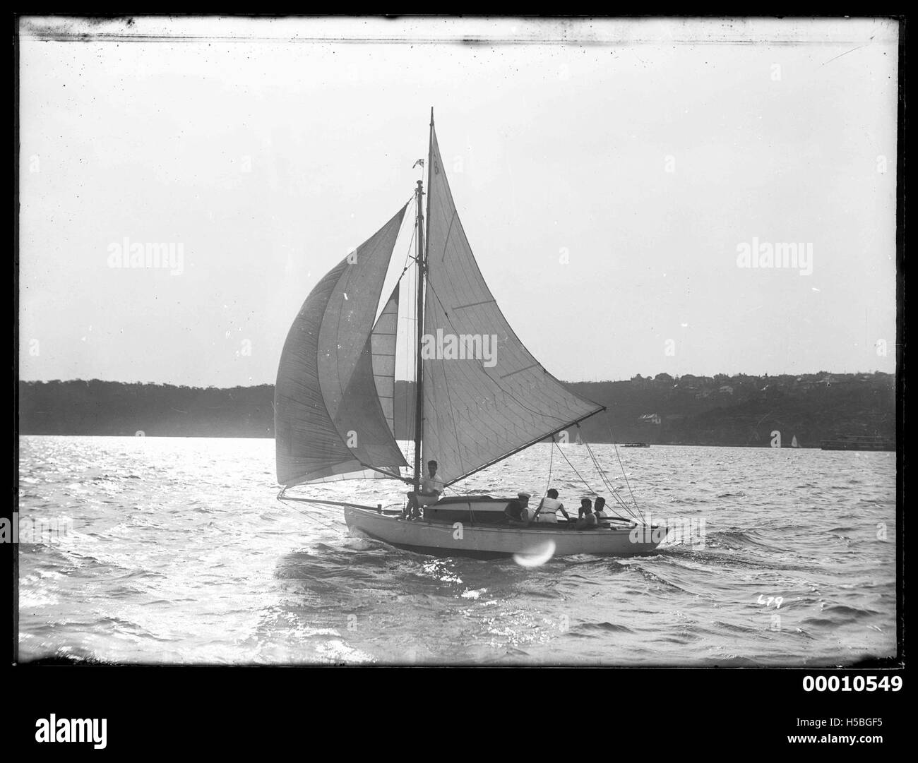 A sloop is seen sailing on Sydney Harbour, capturing the beauty of this ...