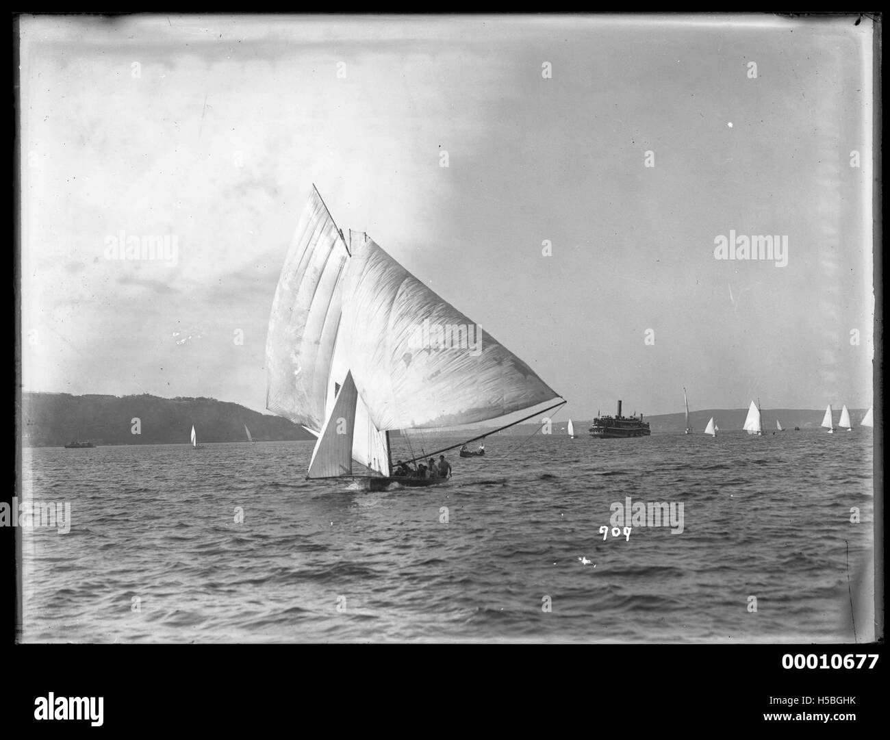 A photograph of a yacht under sail on Sydney Harbour, capturing the ...