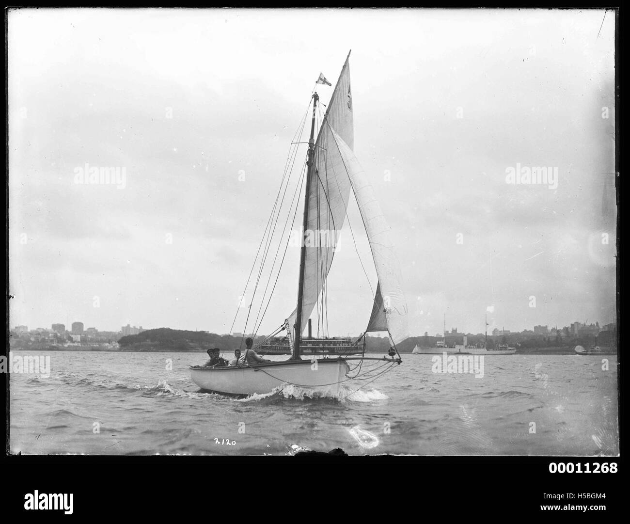 A sloop, a type of sailboat, is seen navigating Sydney Harbour. Known ...