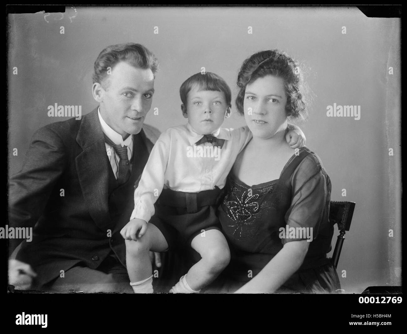 A group portrait features an unknown family, with a backdrop of ...