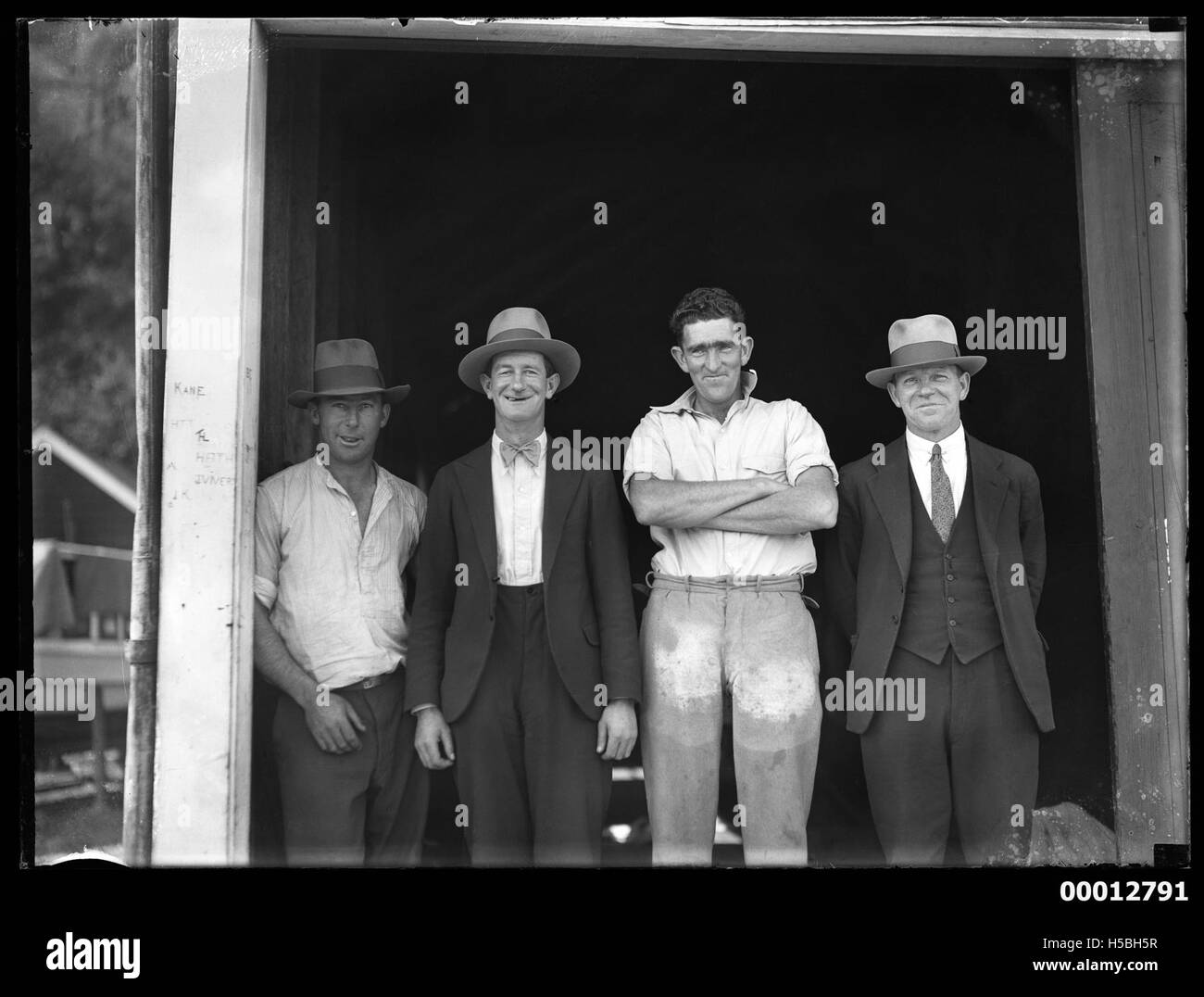 The photograph shows four men outside the boatshed of the Sydney Church ...